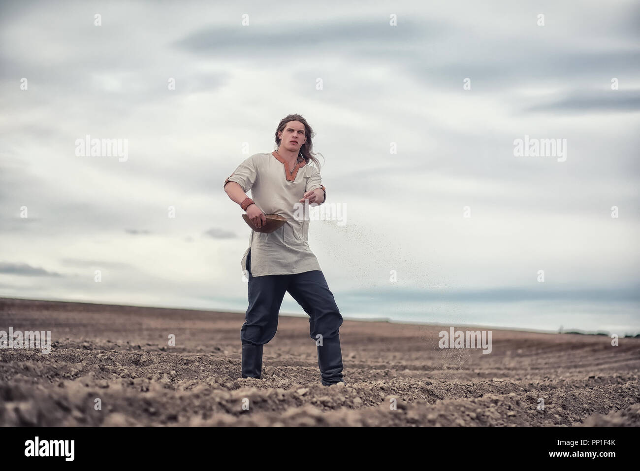 A young peasant sows the field with grain Stock Photo - Alamy