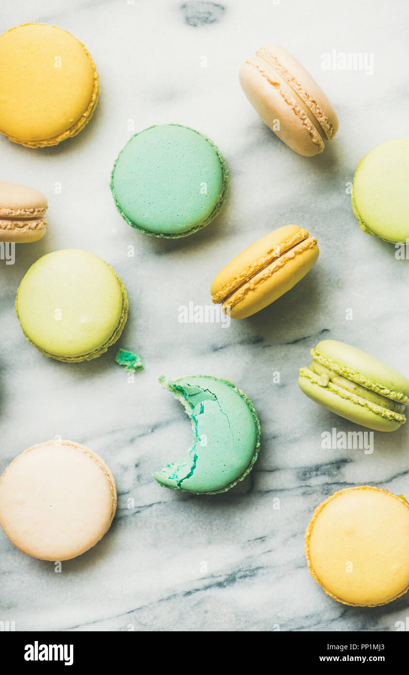 Colorful French macaroons over grey marble background, vertical ...