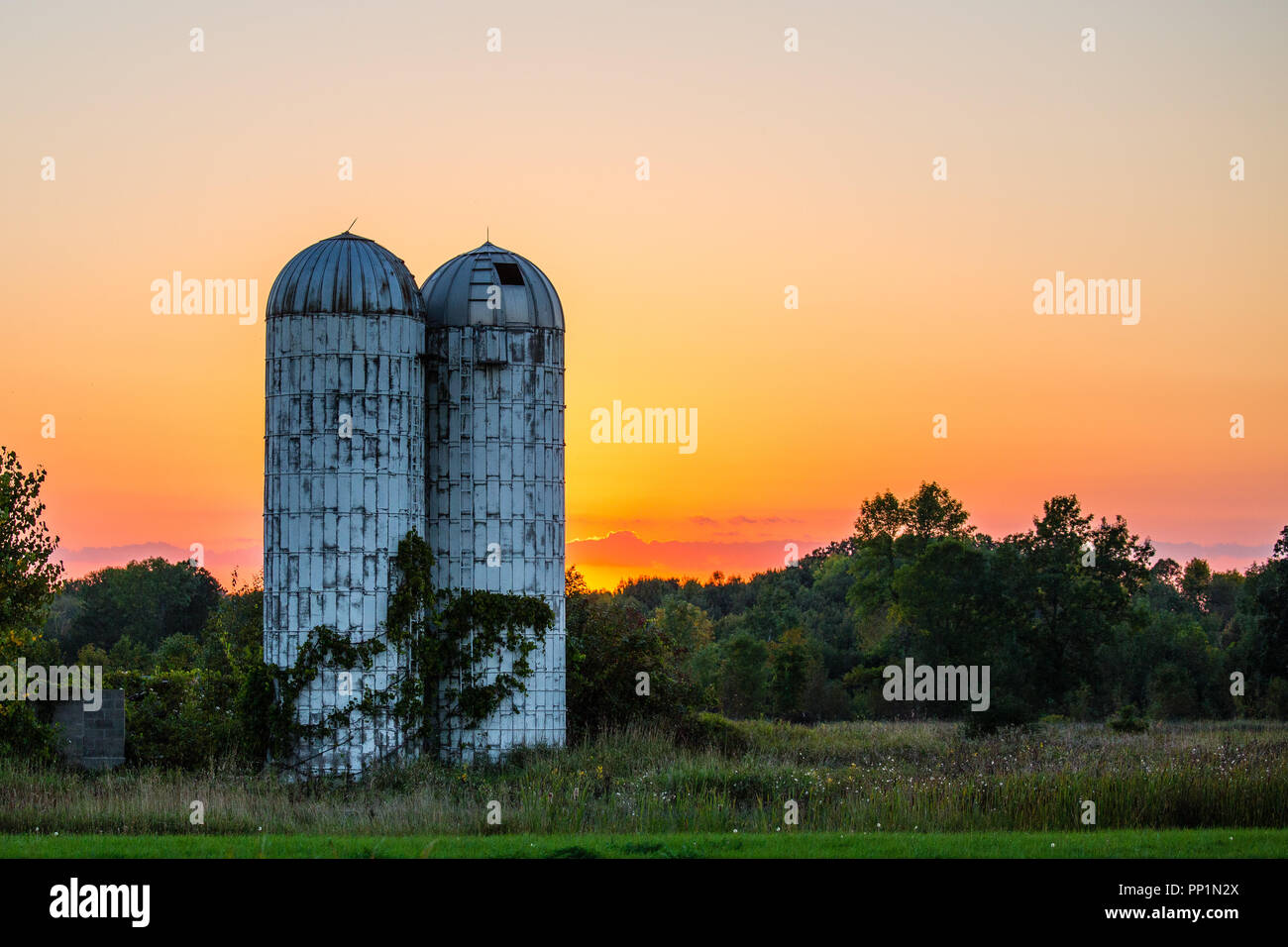 Pair of old silos in front of a Wisconsin sunset Stock Photo - Alamy
