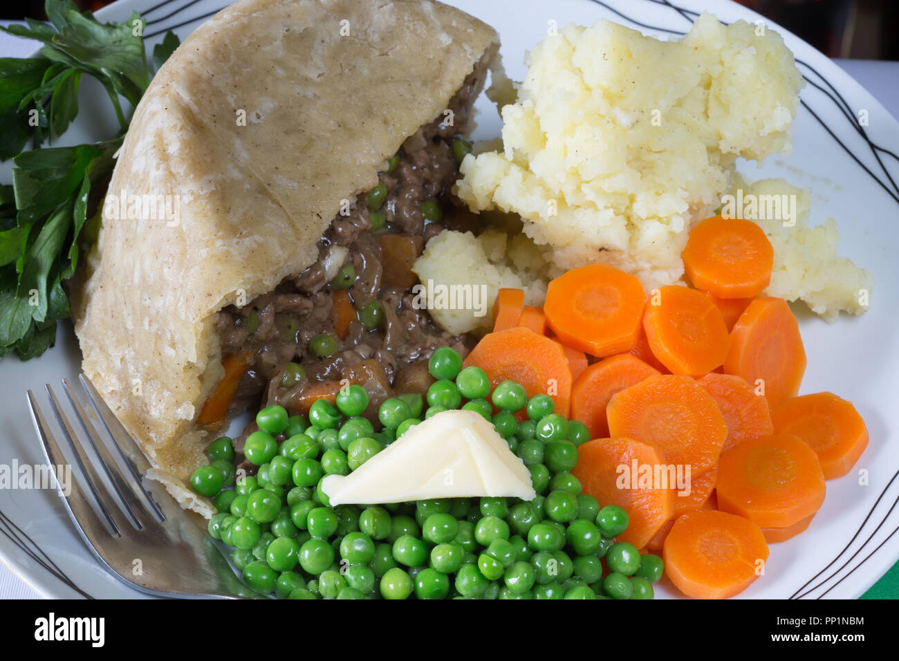 English pub/restaurant dish of steamed beef pudding served with garden ...