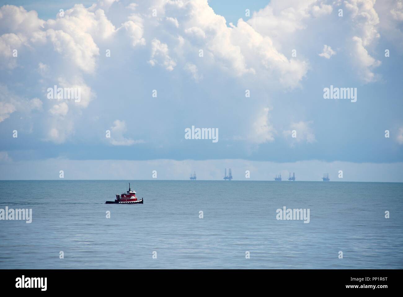 Tug boat heads to port in South Padre Island, Texas. Offshore oil rigs ...