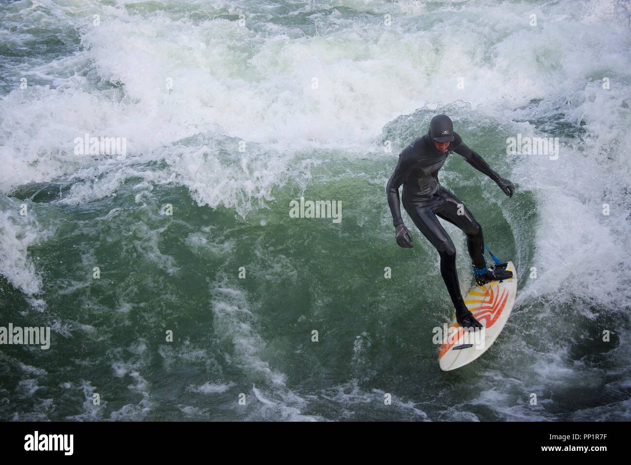A surfer rides the continuous wave in the Eisbach river in the ...