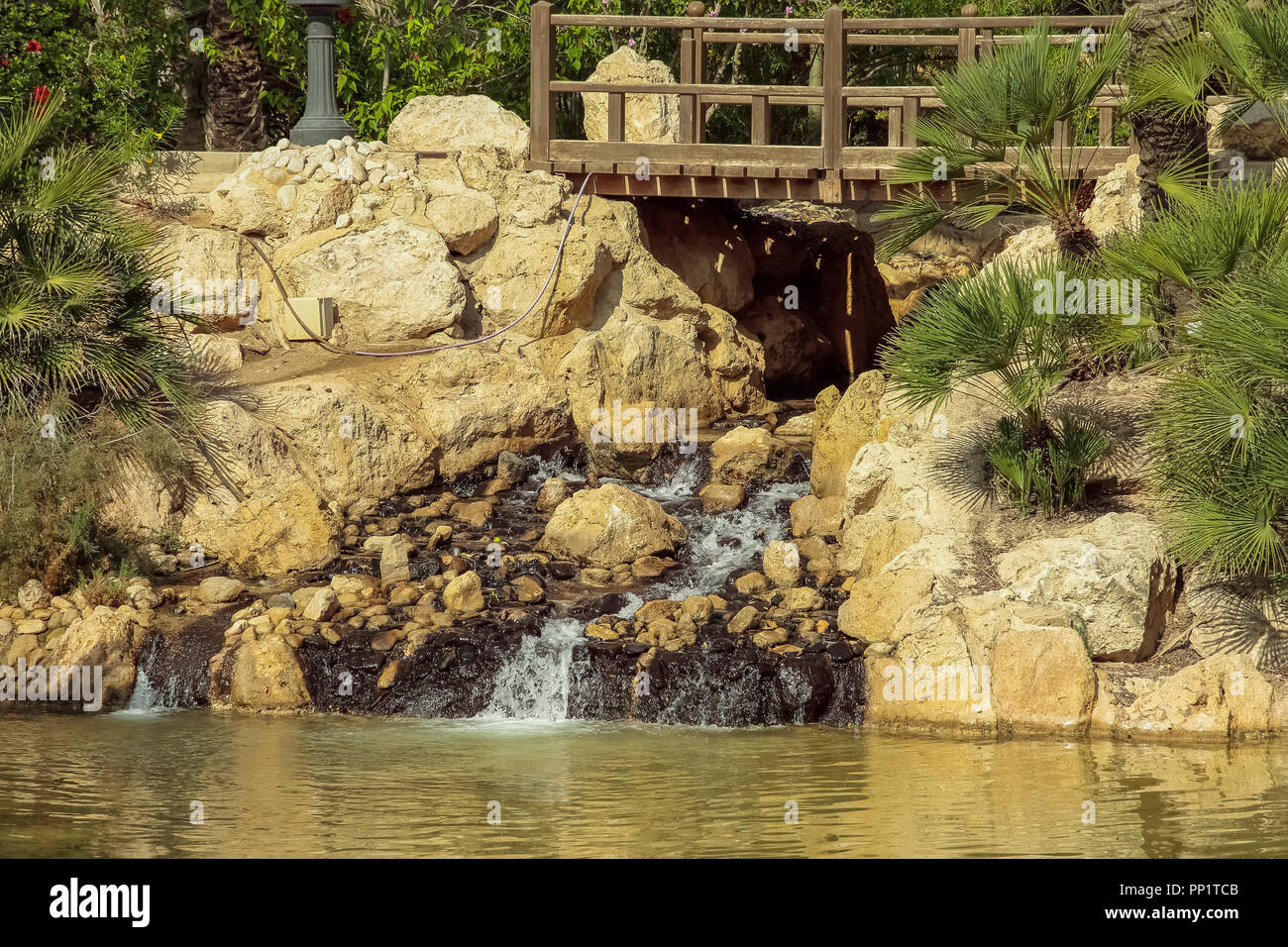 horizontal view of a little cascade and wooden bridge in El palmeral ...