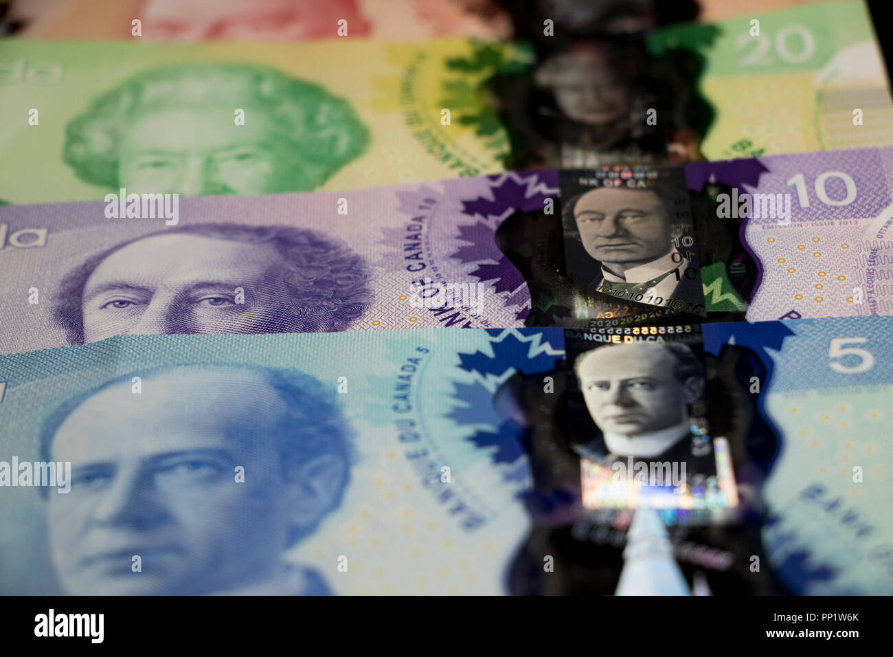 Canadian currency laying flat on a table. Different color and ...