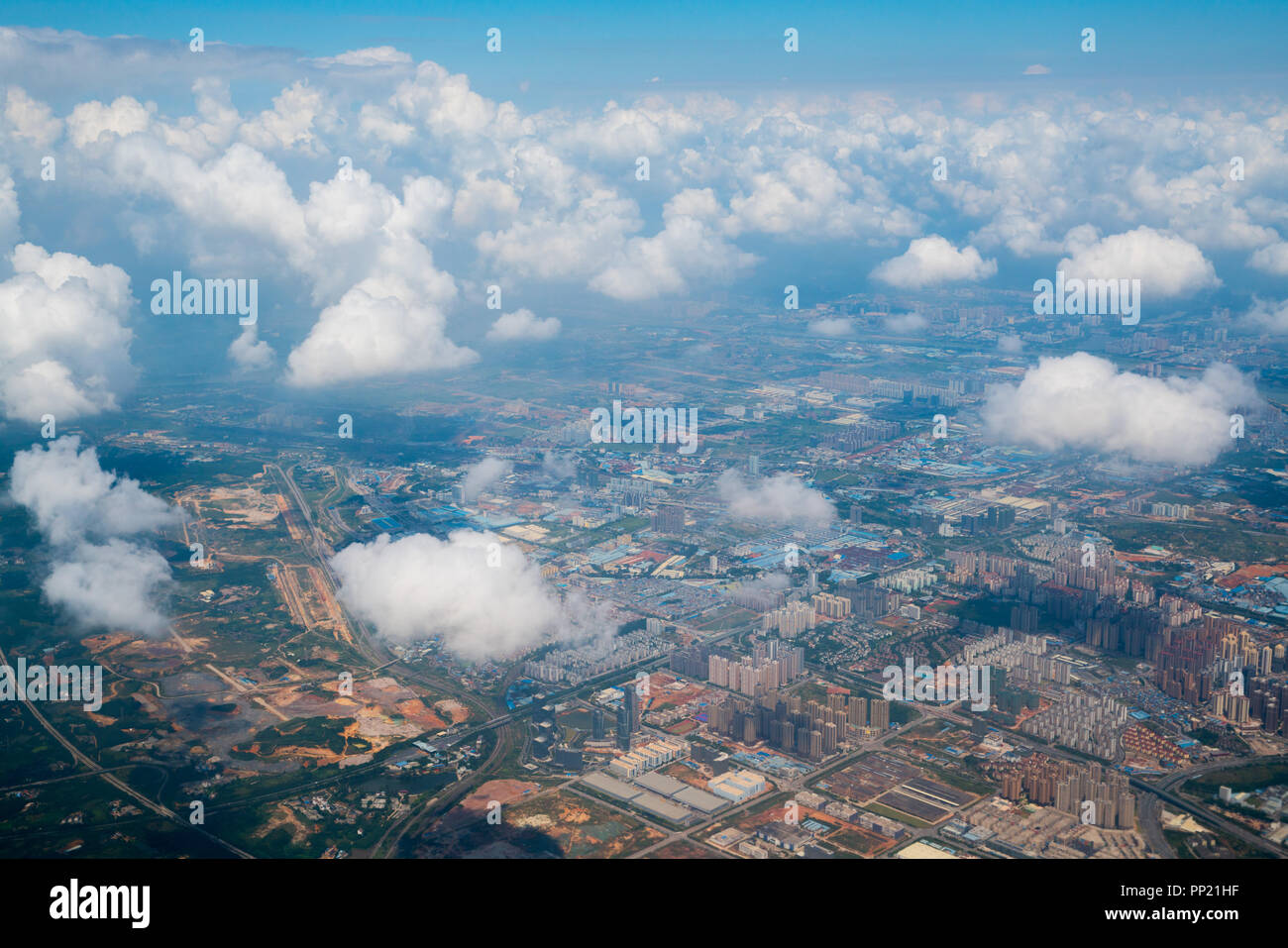 aerial view, flying above the puffy white clouds and over ground ...