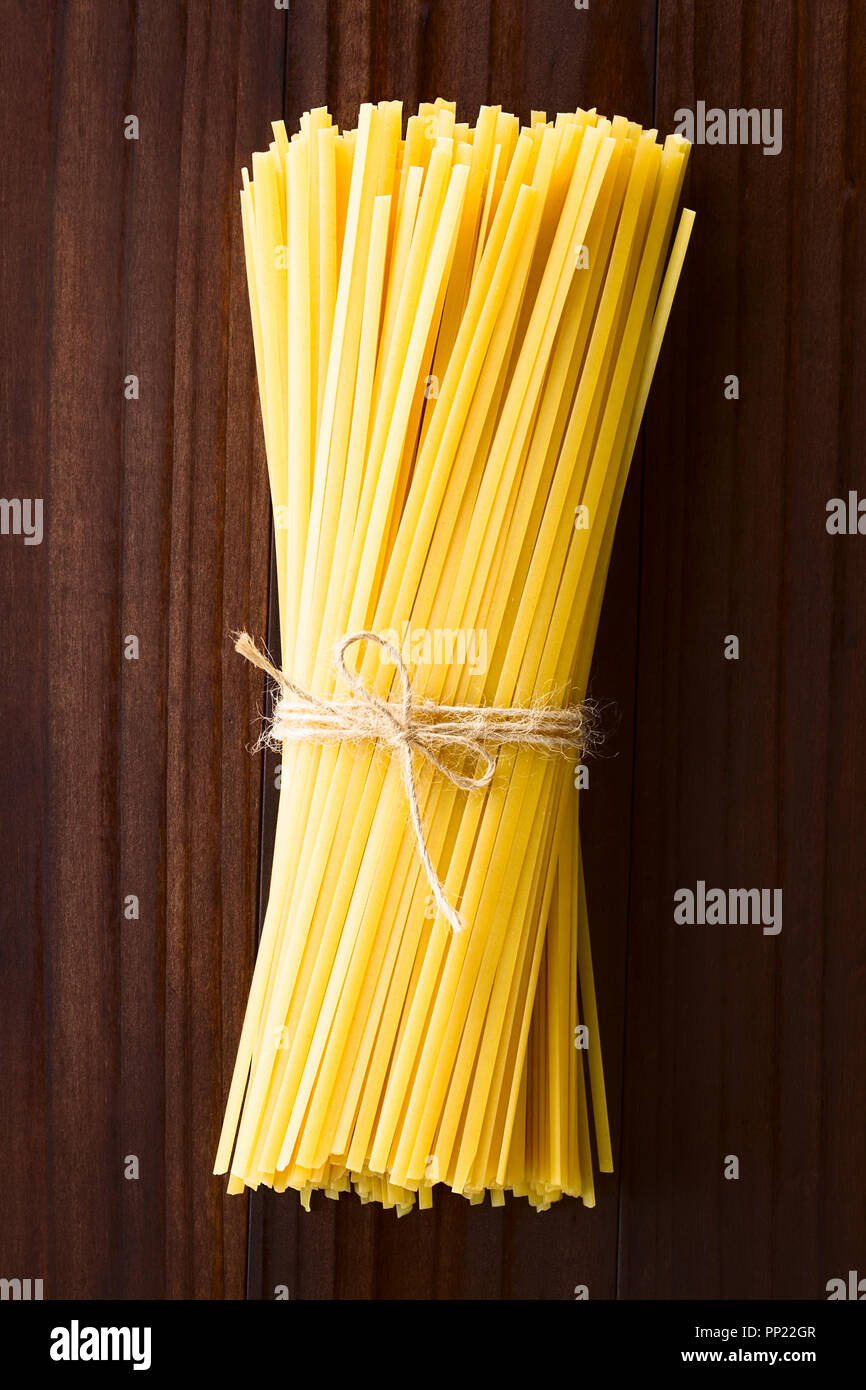 Raw flat long ribbon pasta called Fettuccini tied in a bundle ...