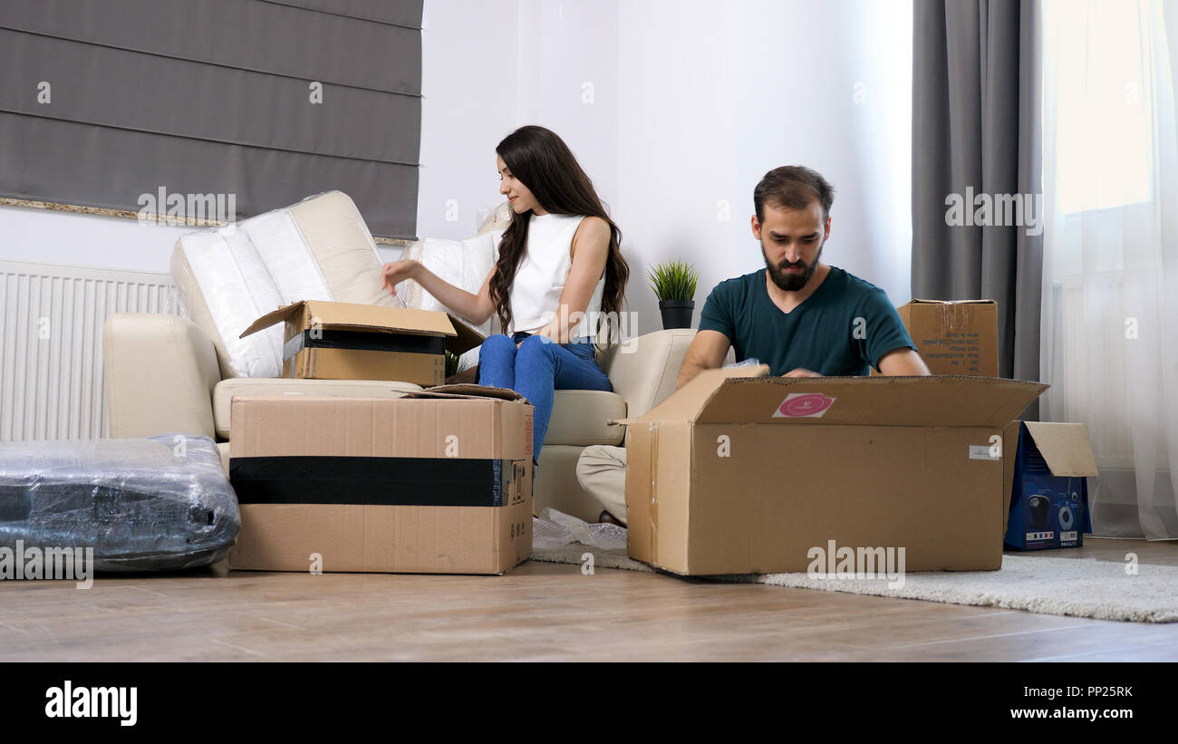 Young couple Moving in new home and unpacking carboard boxes. Almost ...