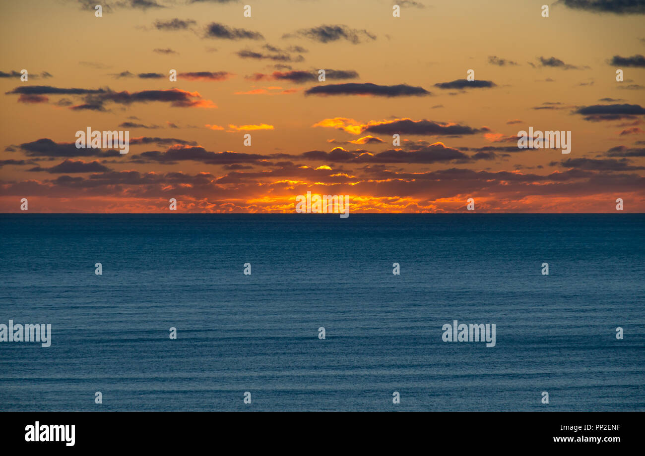 Ocean sunset with swell lines rolling towards the shoreline Stock Photo ...
