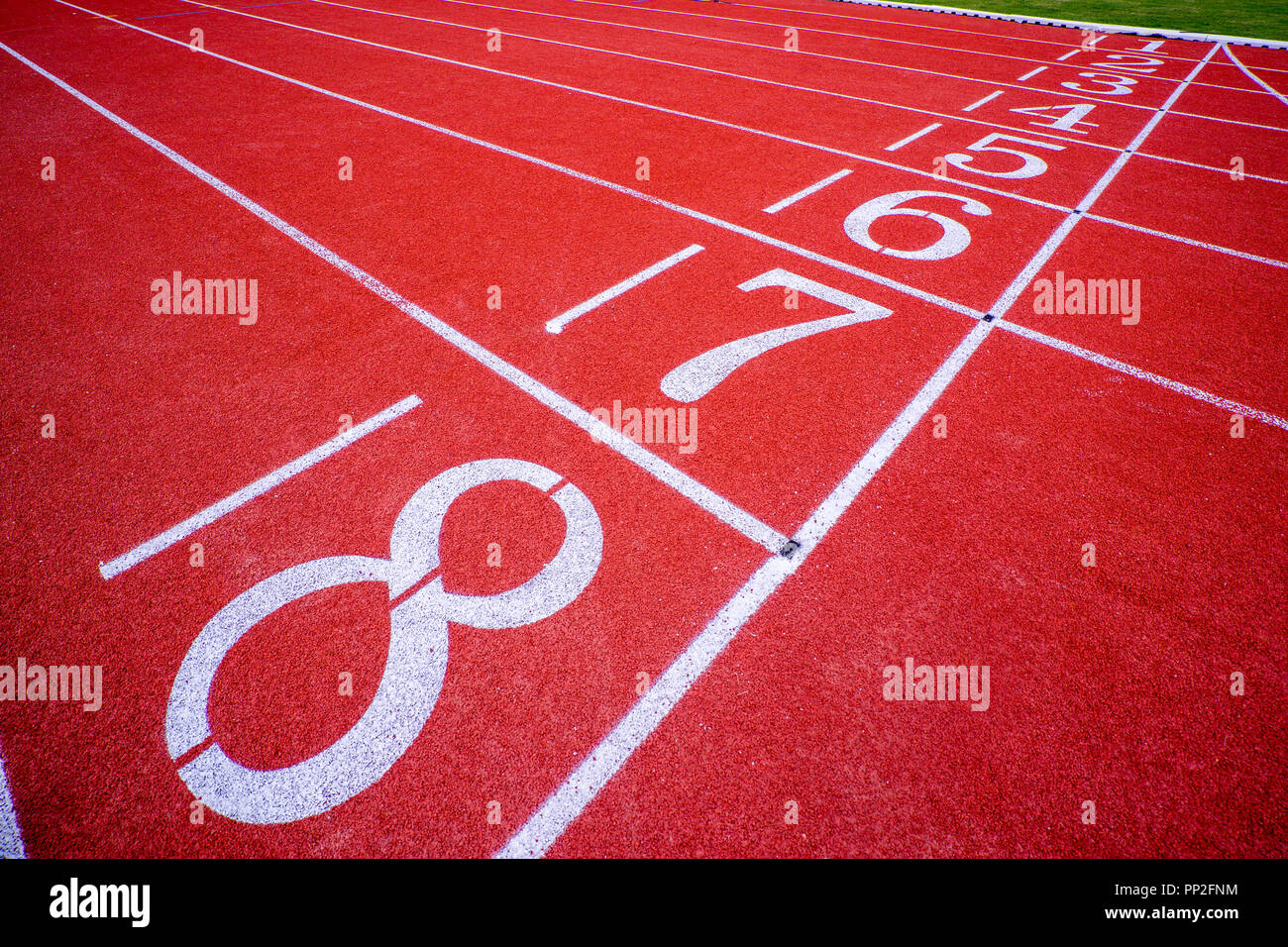 red surface running racetrack with white lines and number in outdoor ...