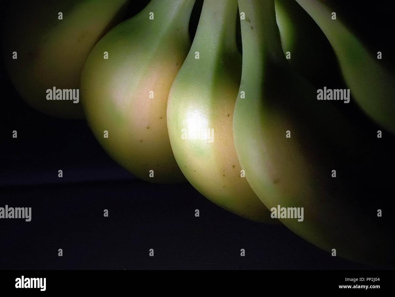 Bunch of Bananas in low light Stock Photo - Alamy