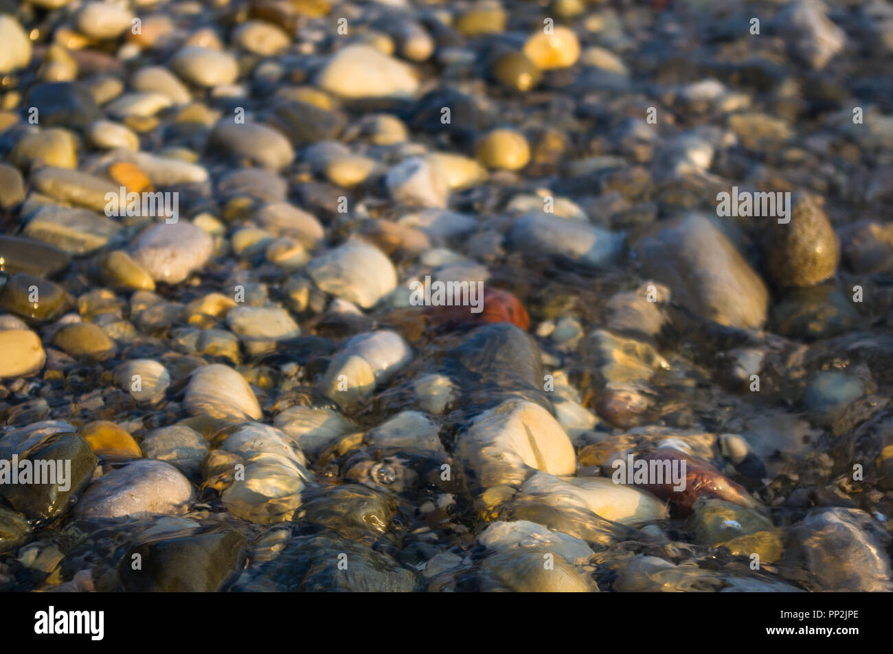 pebble stones on the sea beach on a warm summer day, the rolling waves ...