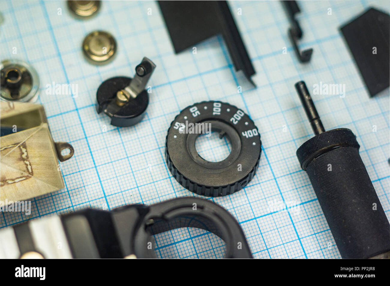 parts are completely disassembled old retro film SLR camera on graph ...
