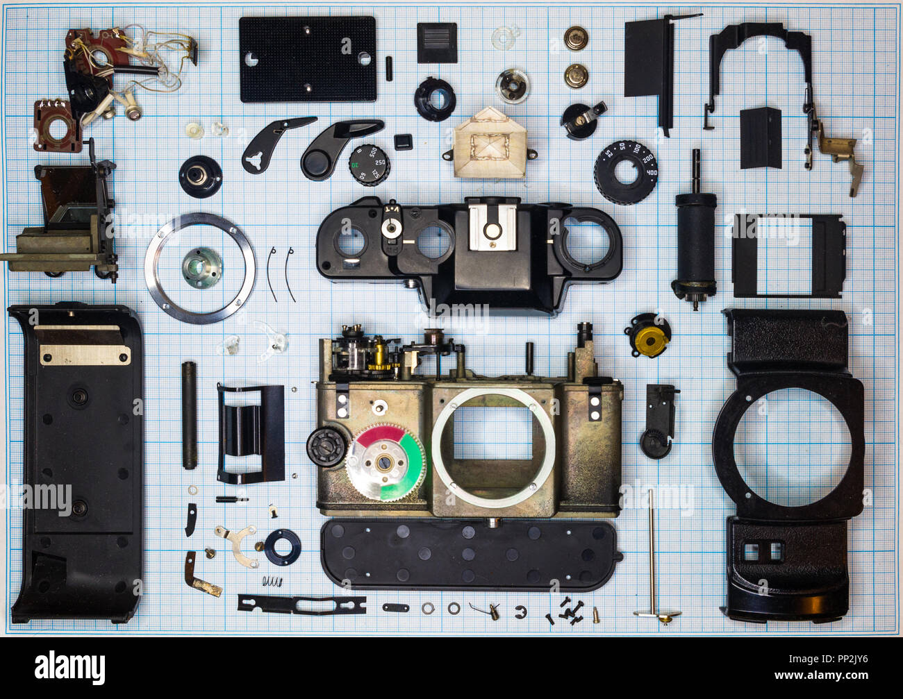 parts are completely disassembled old retro film SLR camera on graph ...