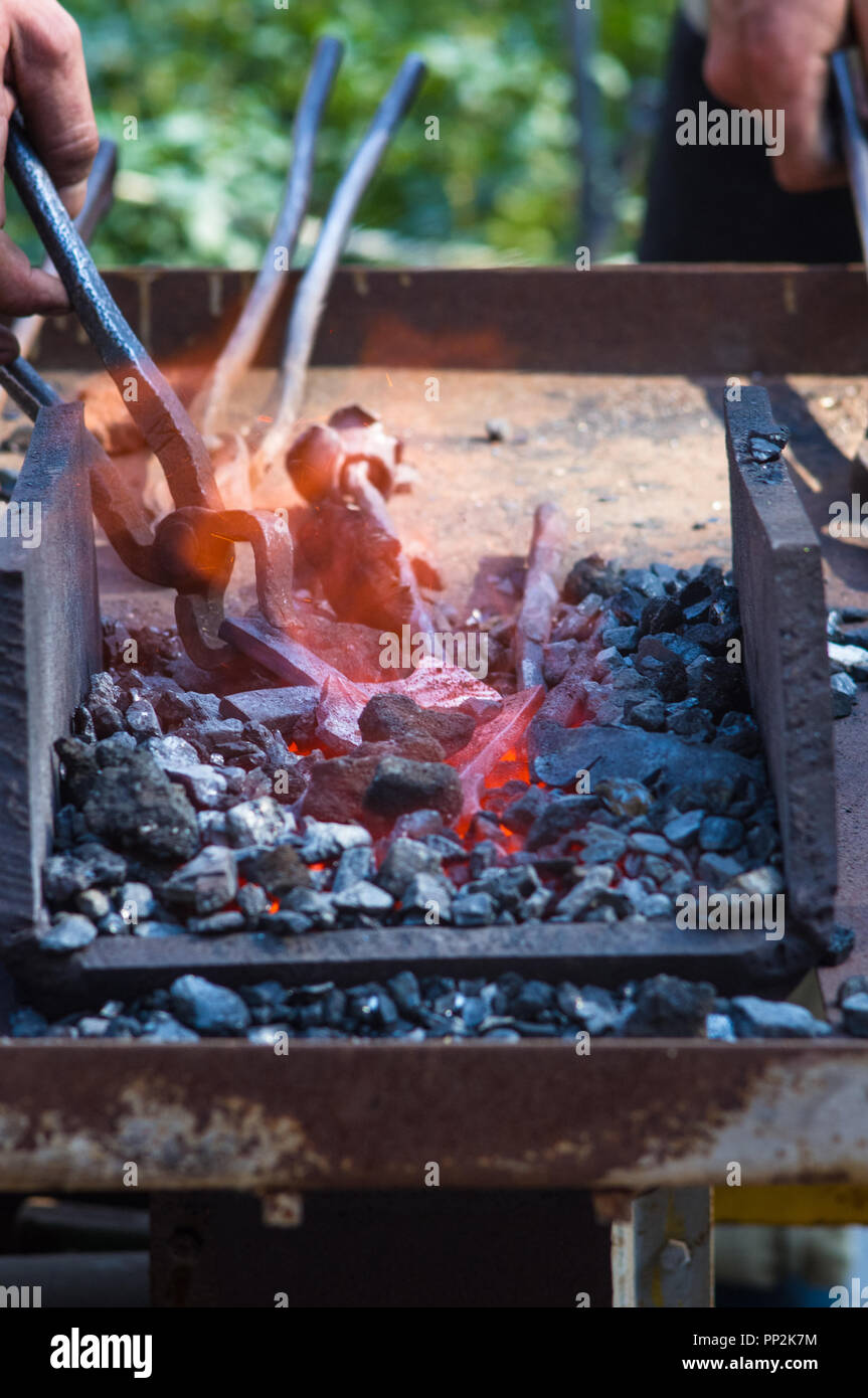 blacksmith furnace with burning coals, tools, and glowing hot metal ...