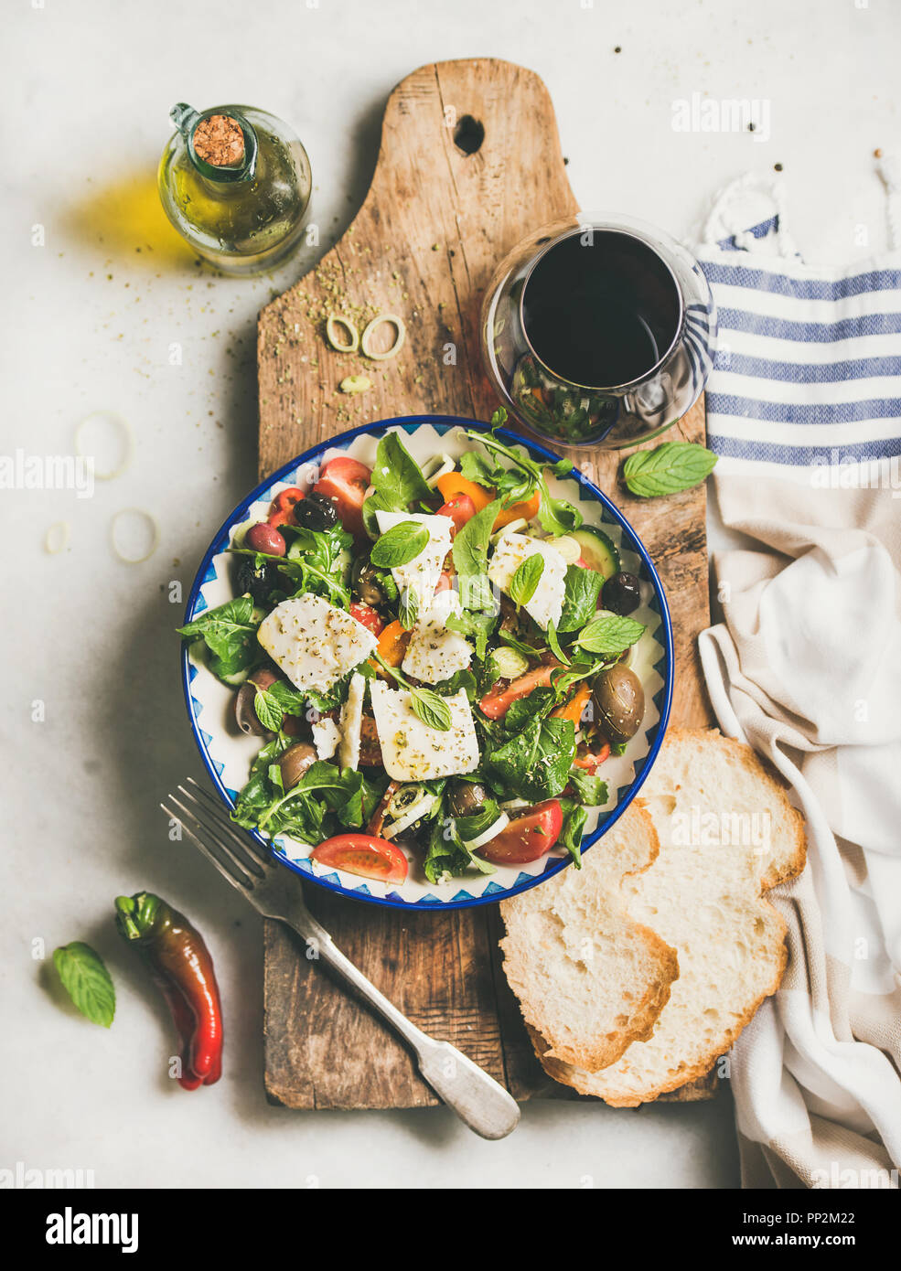 Flat-lay of traditional Greek salad with feta cheese, olive oil and ...