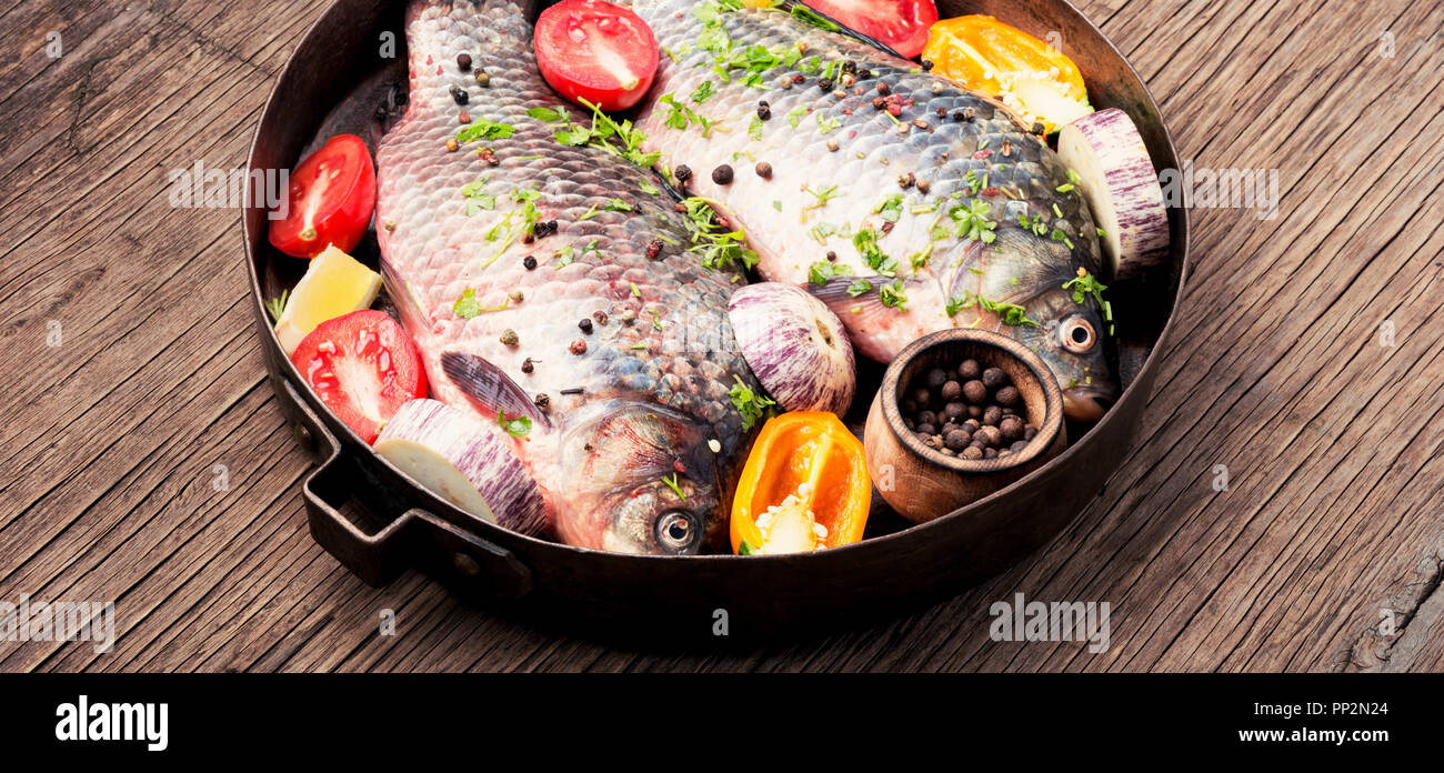 Fresh fish with ingredients for cooking on pan Stock Photo - Alamy