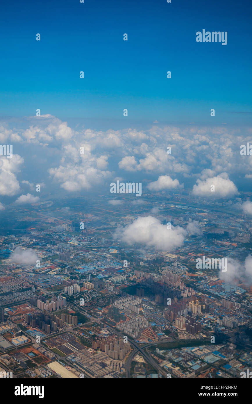 aerial view, flying above the puffy white clouds and over ground ...