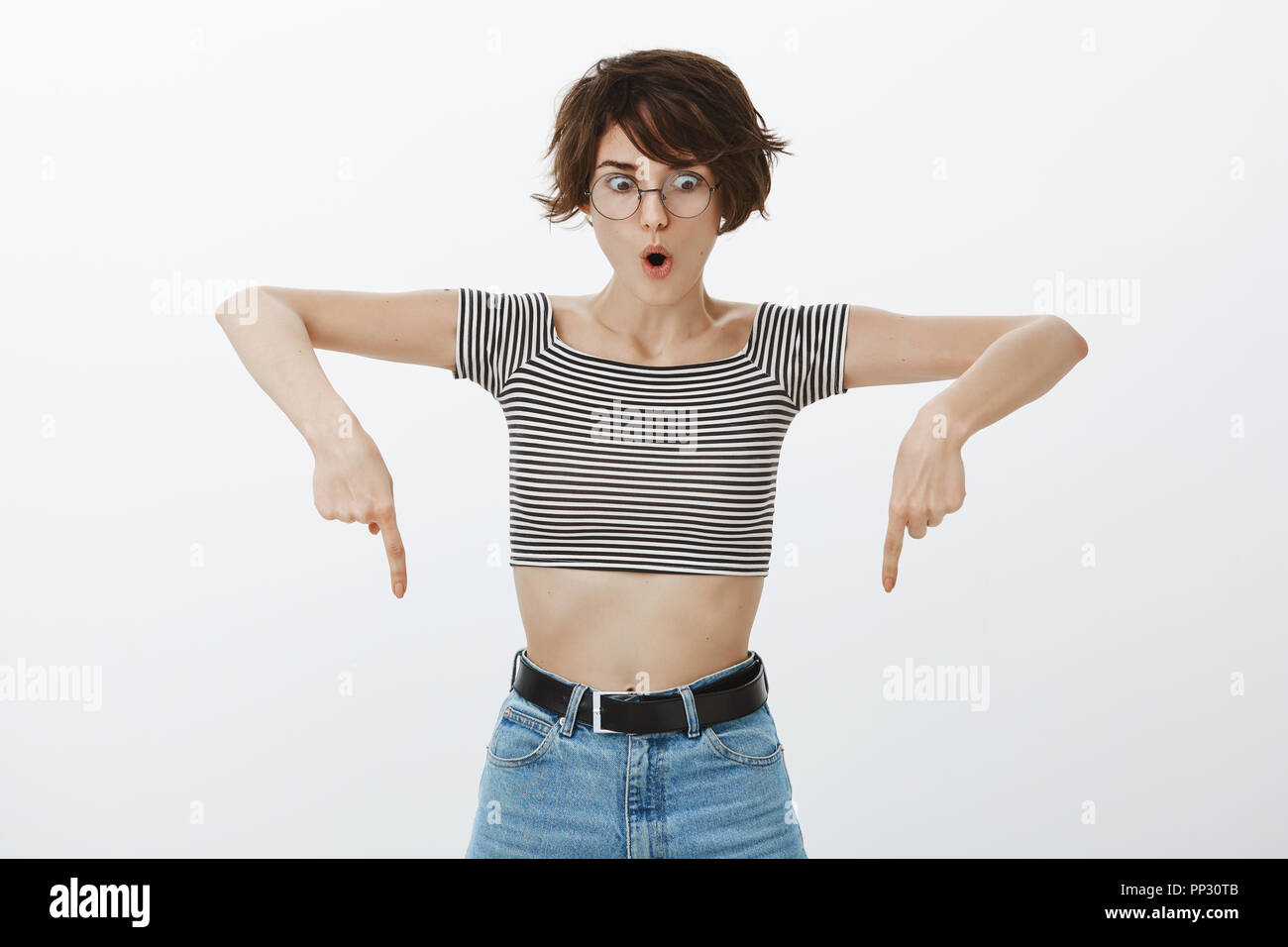 Omg, look down. Portrait of shocked and stunned attractive female with ...