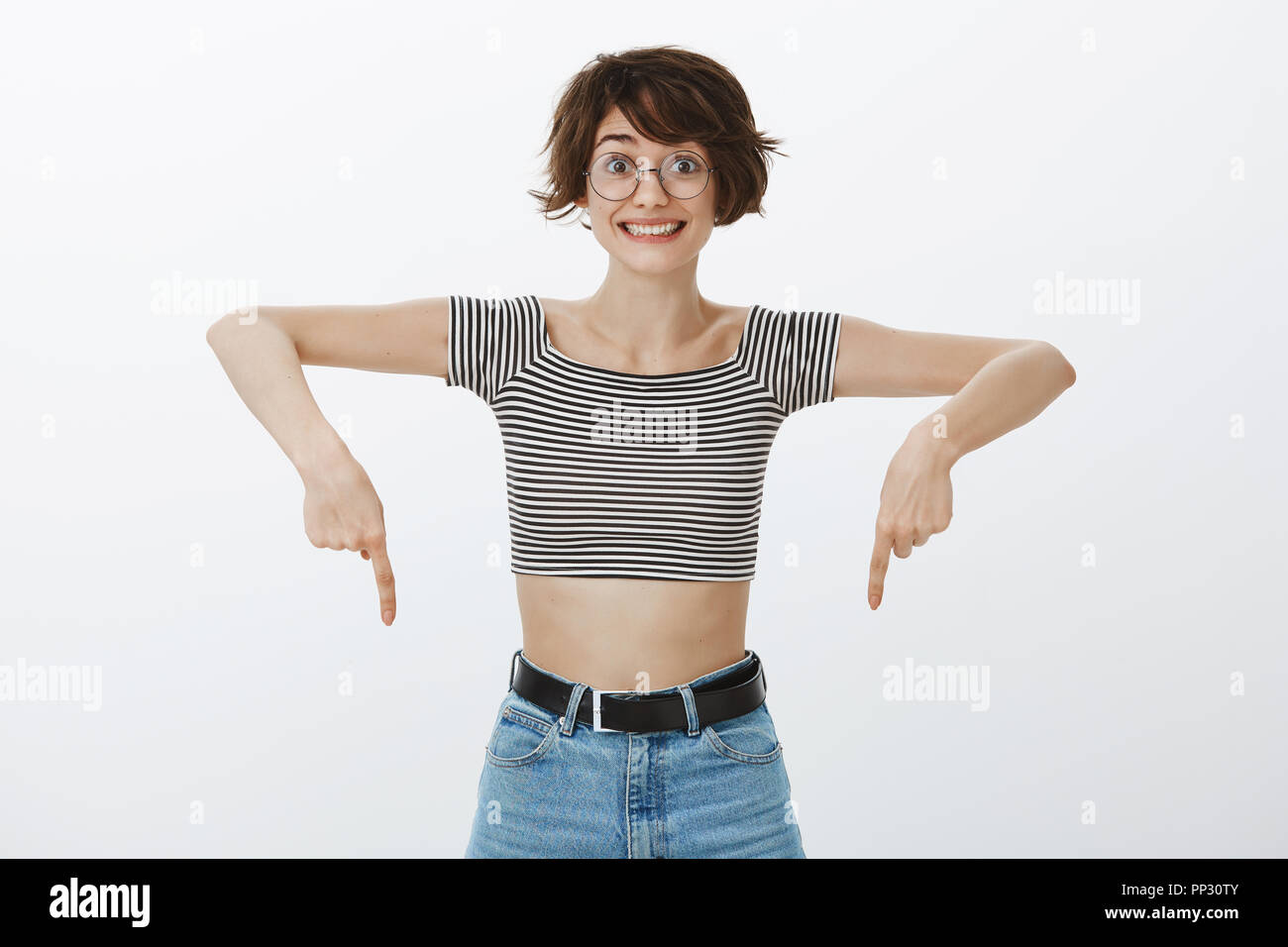 Excited positive and joyful cute female coworker in round glasses and ...