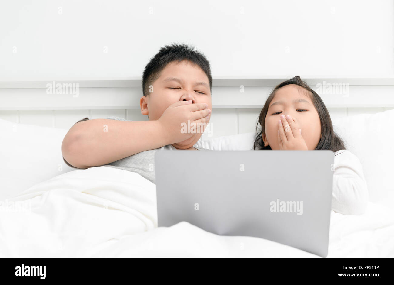 children are yawning and play computer on bed,internet and education ...