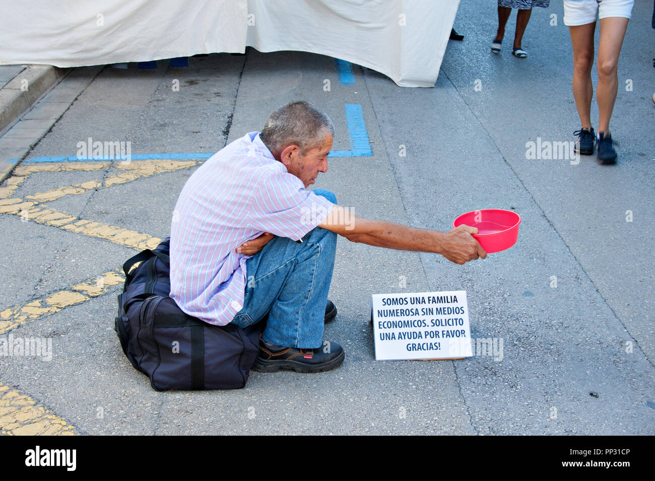 A spanish man begging in a busy market street in spain Stock Photo - Alamy