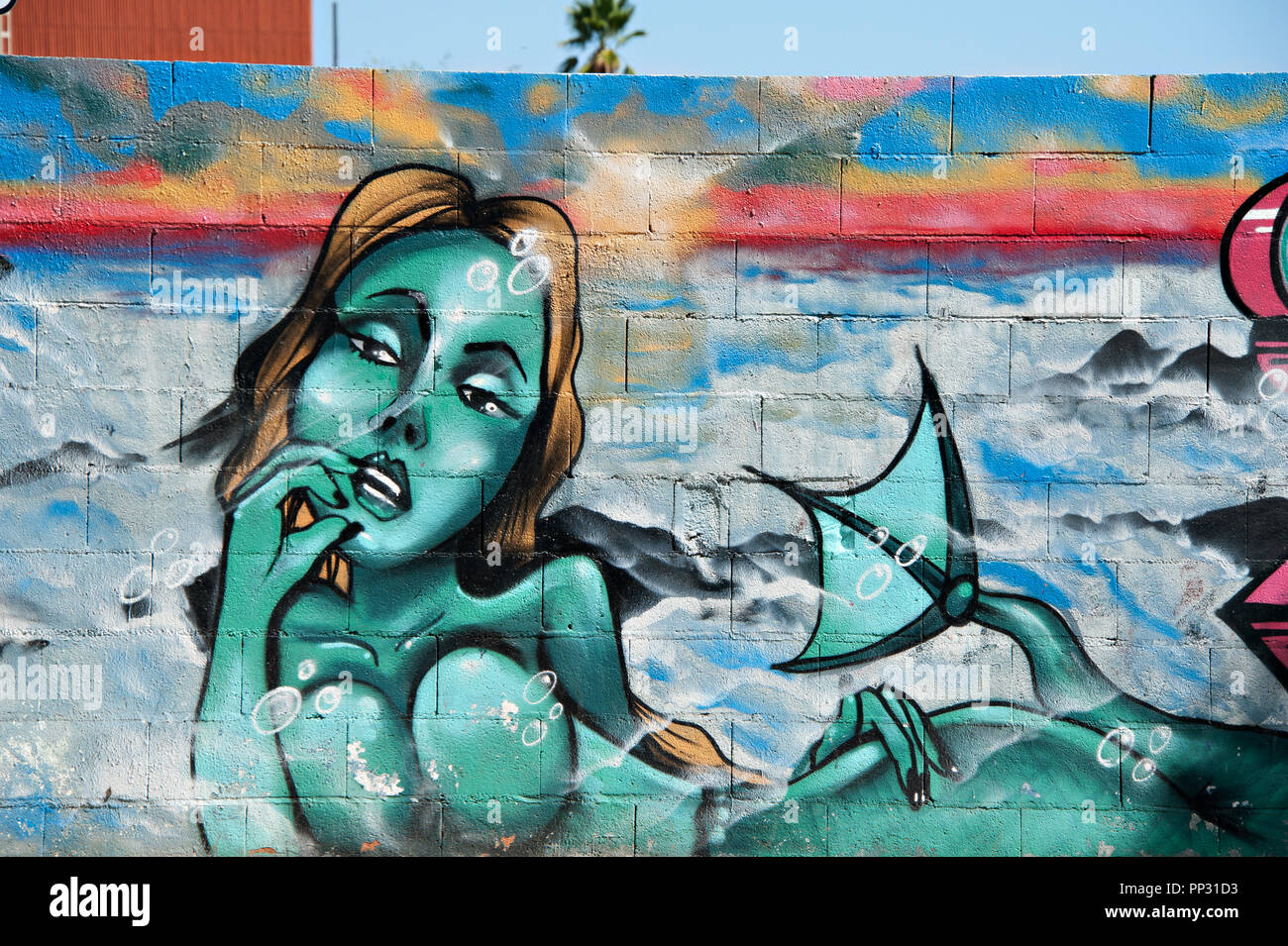 graffiti artists painting of a green mermaid on a wall in spain Stock ...