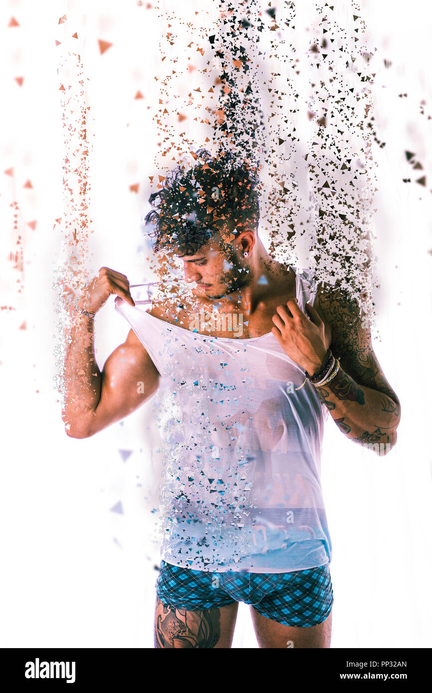 Dispersion effect of handsome man in wet tank top and pants standing on ...