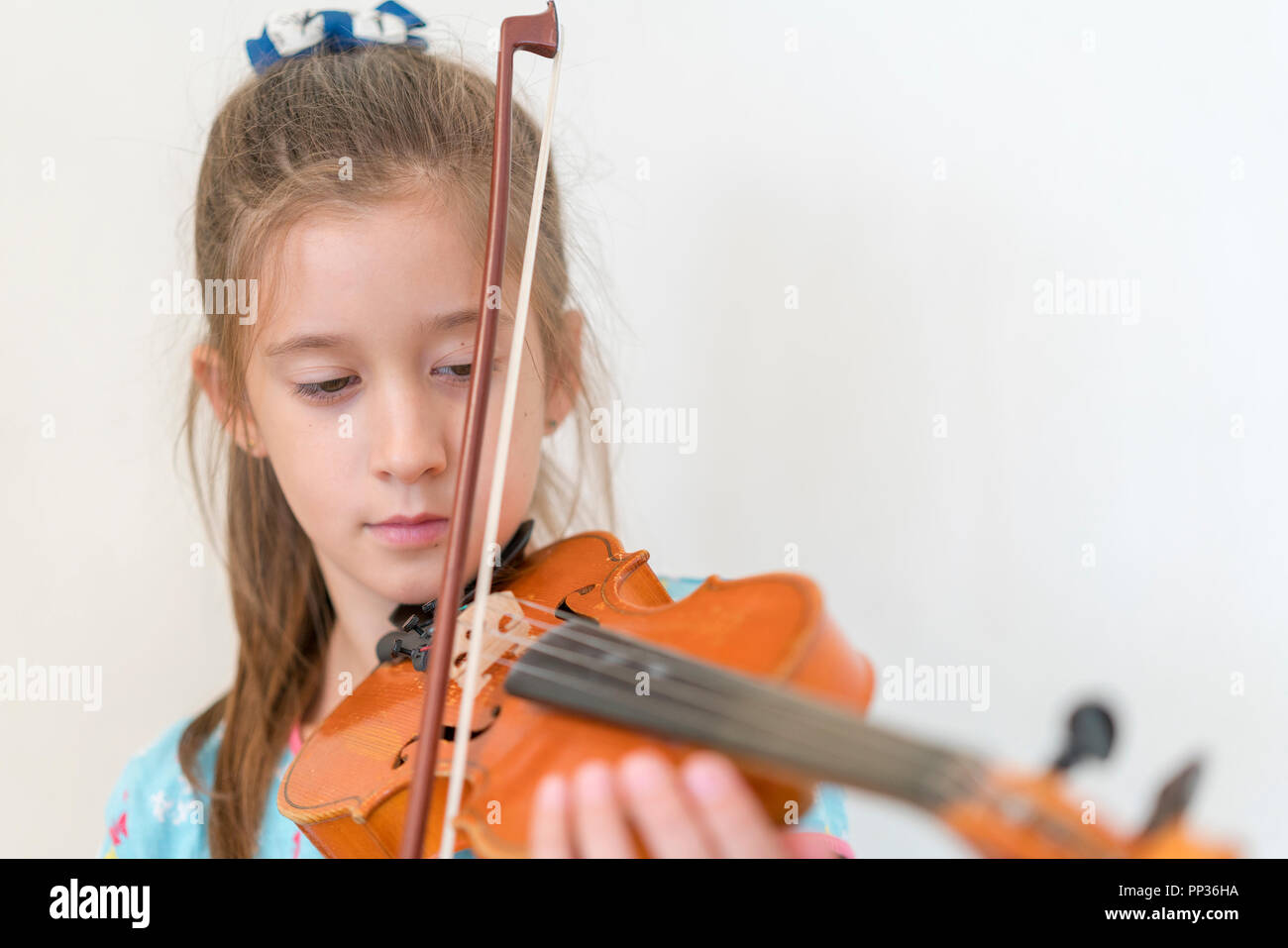 Portrait of a young blond teenage girl playing violin. Girl playing the ...