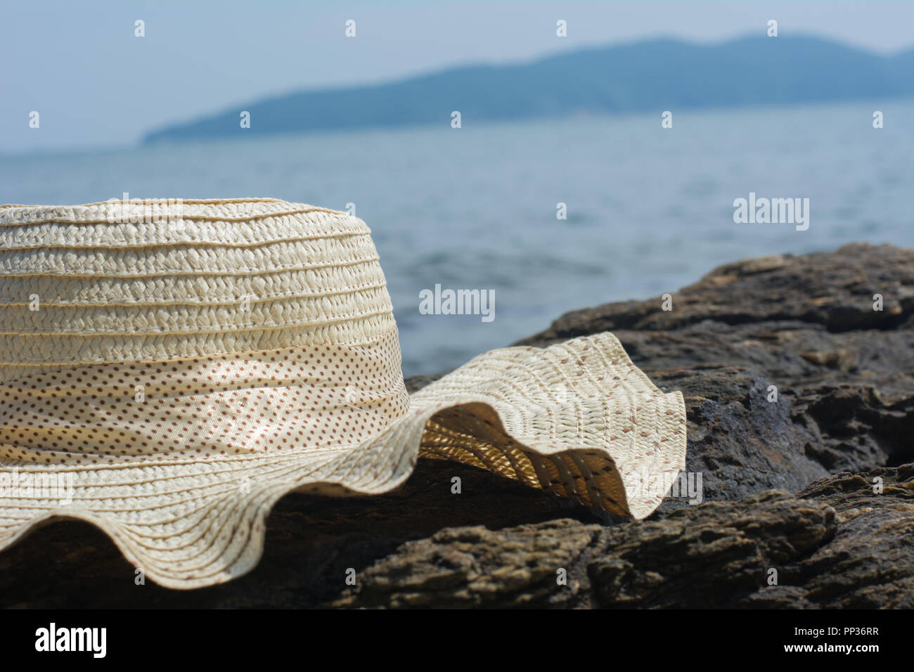 The hat is placed on the rocks by the sea in the sun Stock Photo - Alamy