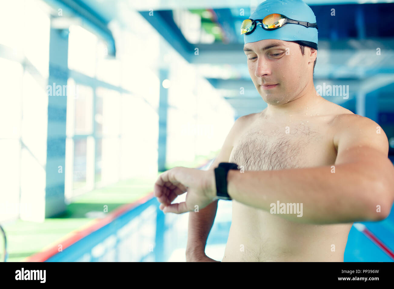 Image of young swimmer with timer on arm standing in pool during ...