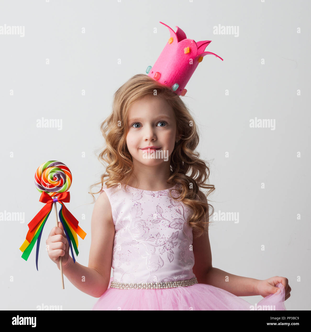 Beautiful little candy princess girl in crown holding big lollipop and ...