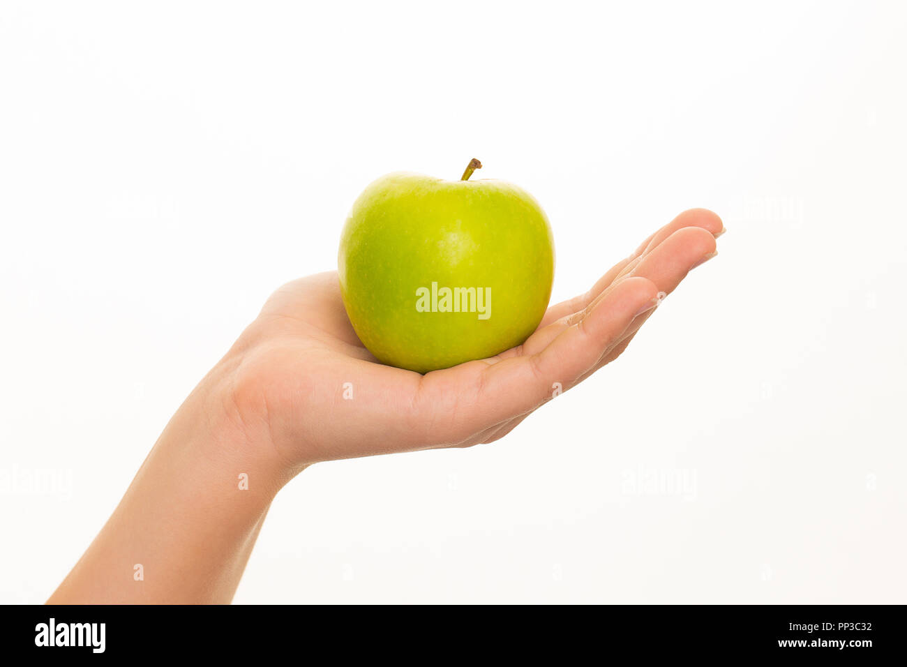 Green Apple being held by a woman's hand on a white background showing ...