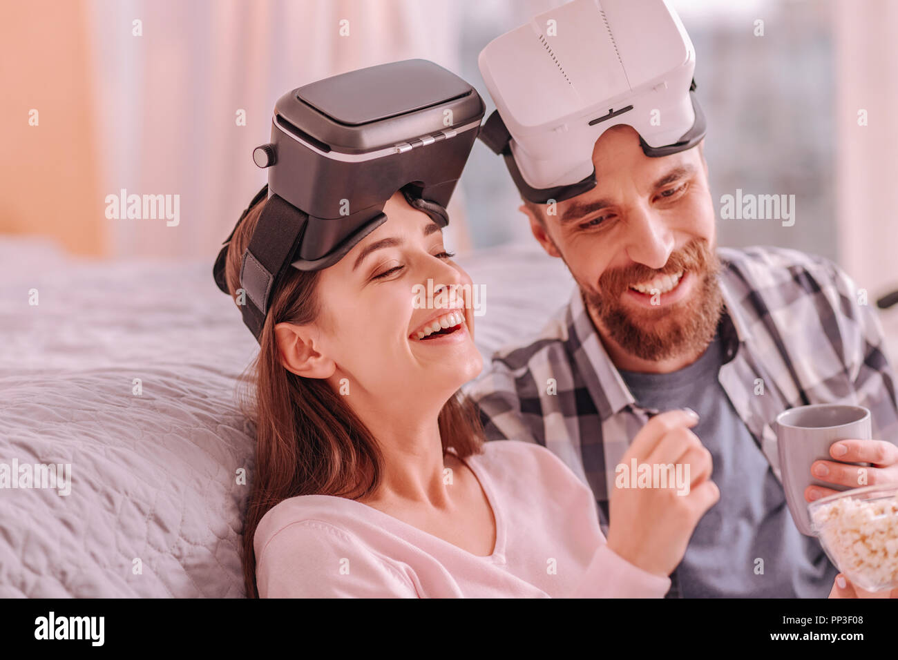 Smiling husband and wife laughing at something Stock Photo - Alamy