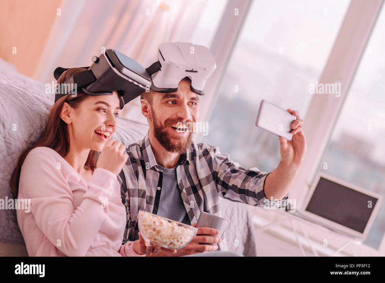 Happy couple making selfie while eating popcorn Stock Photo - Alamy