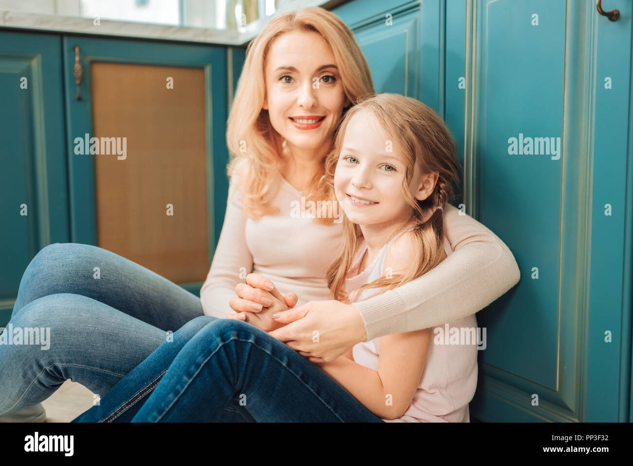 Kind girl sitting near her pretty mother Stock Photo - Alamy