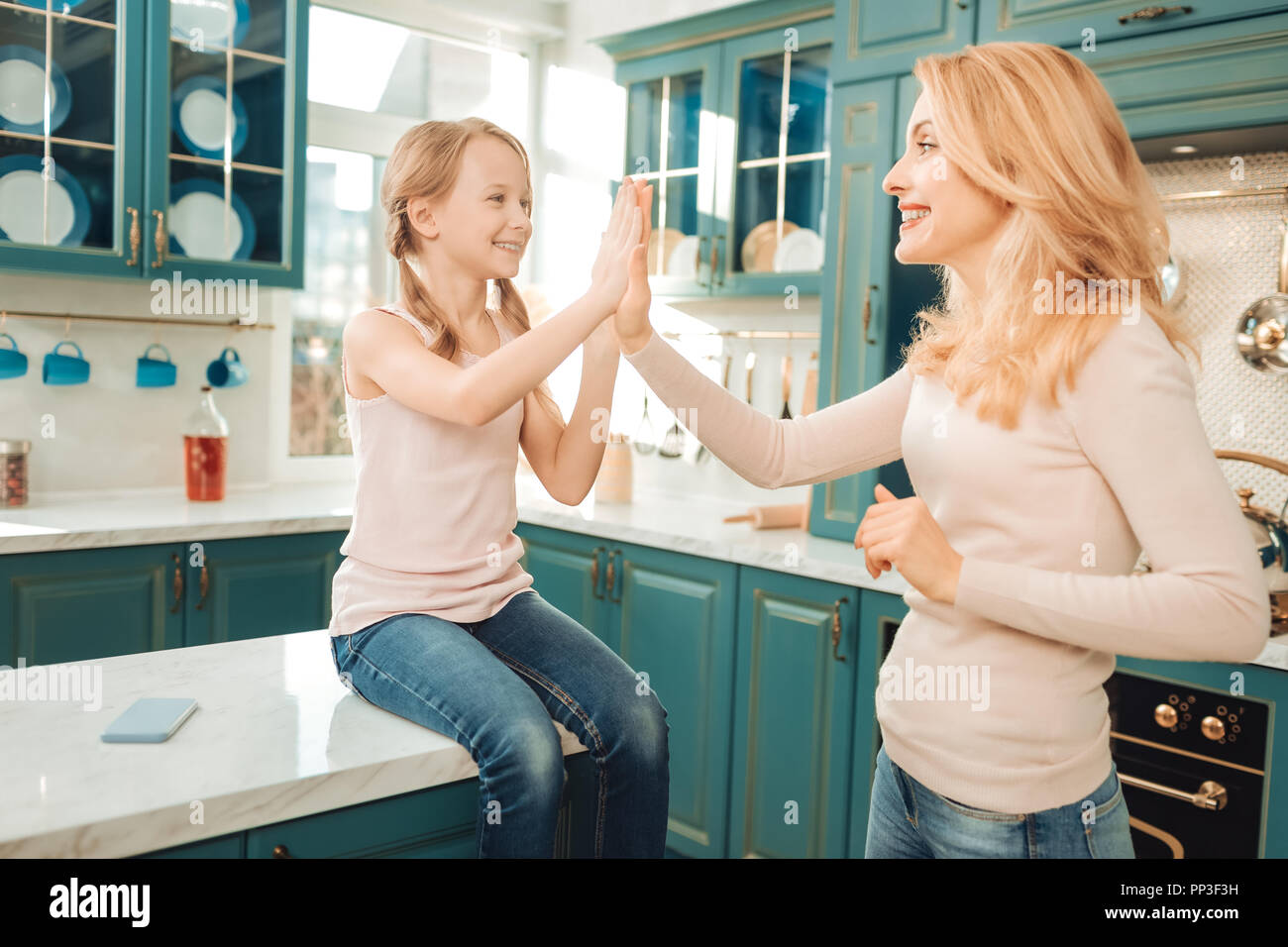 Positive delighted girls touching hands with pleasure Stock Photo - Alamy