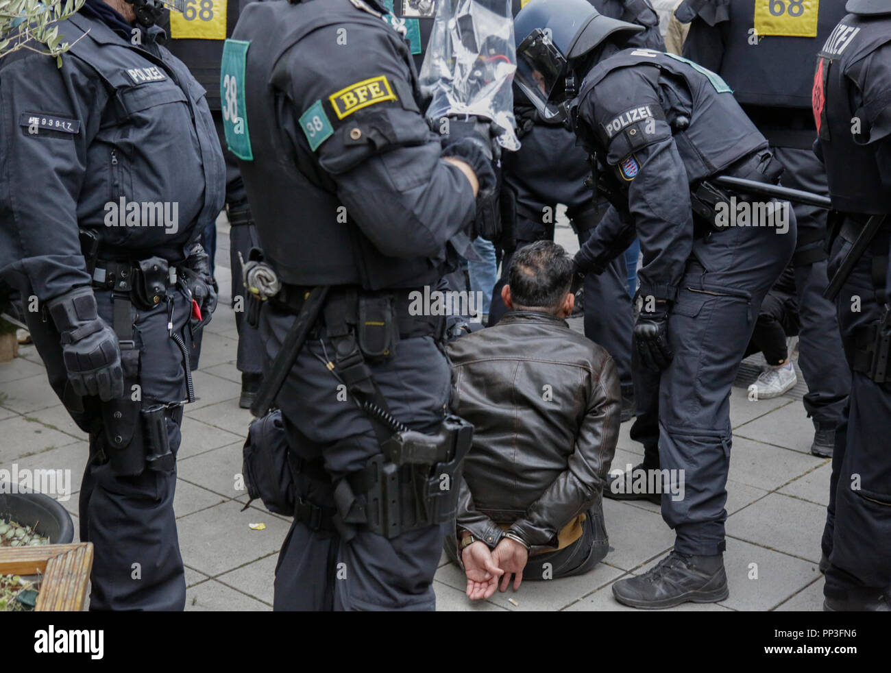 Frankfurt, Germany. 22nd Sep, 2018. A handcuffed protester sits on the ...
