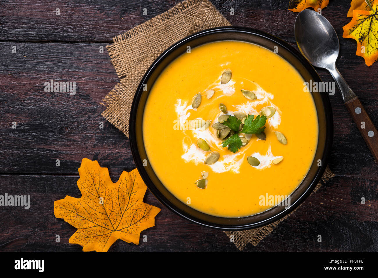 Pumpkin cream soup on dark wooden table Stock Photo - Alamy
