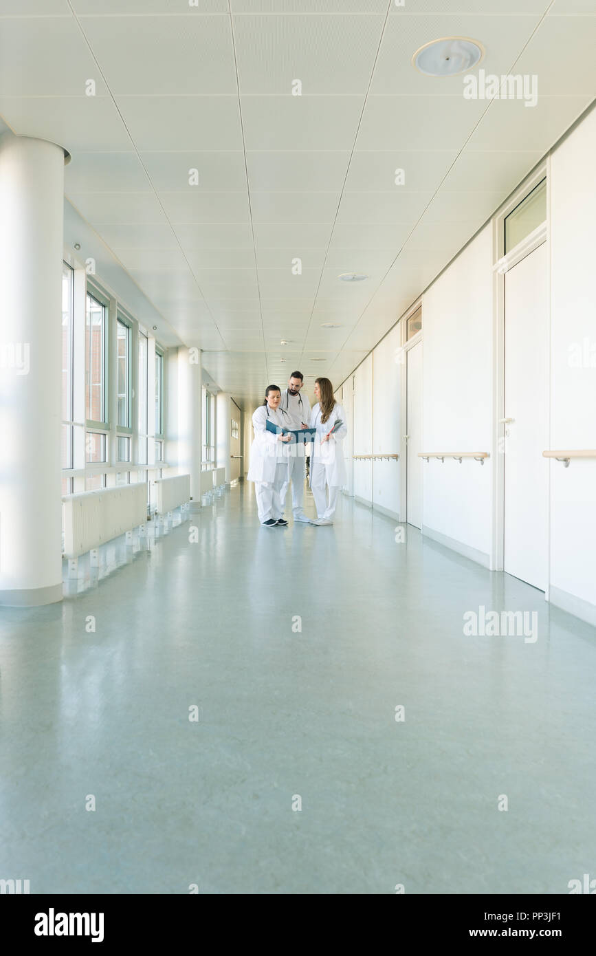 Multicultural Medical Team Having Meeting In Hospital Corridor Stock