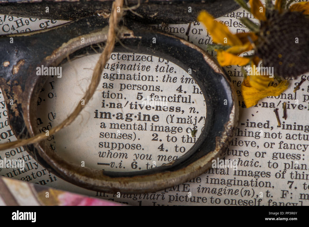 The word imagine centered in old pair of scissors with dried flowers ...