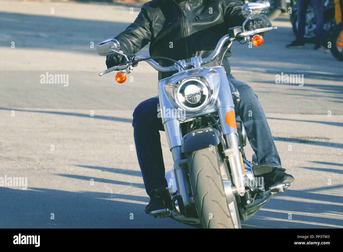 The biker in a leather jacket rides a motorcycle Stock Photo - Alamy