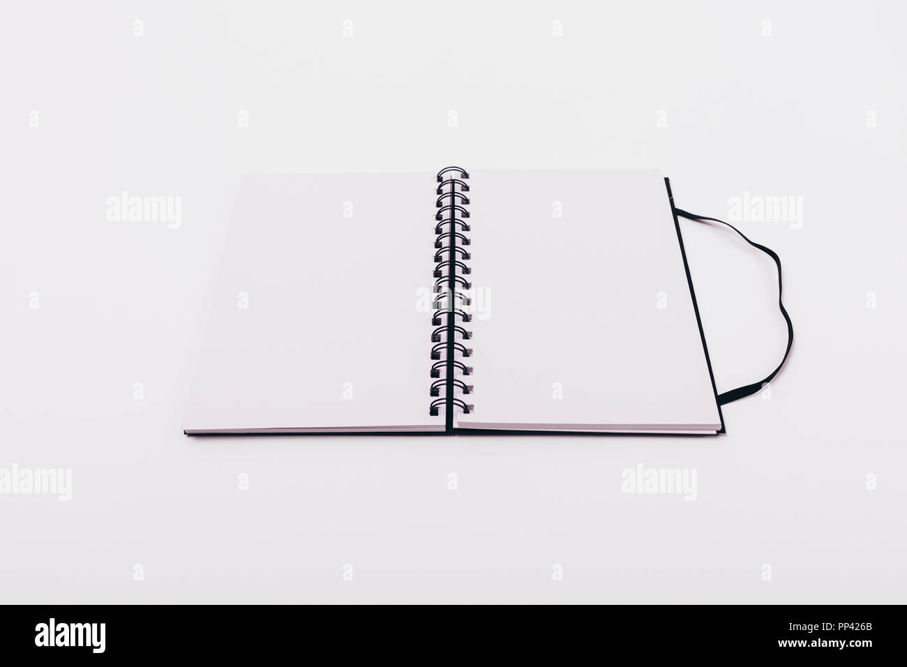 Mock-up open notepad with spring with two blank sheets on white table ...