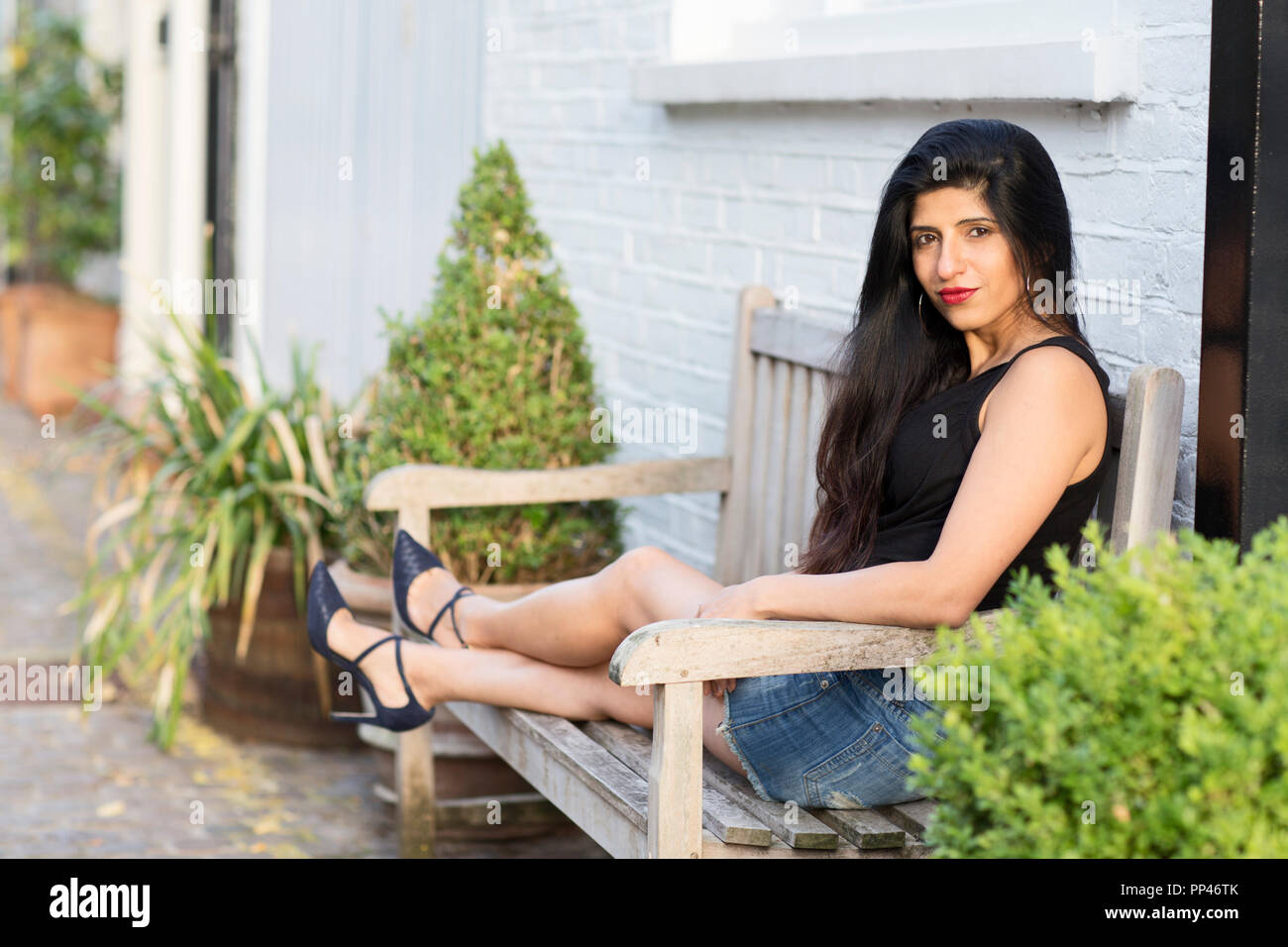 A beautiful indian woman sitting on a bench Stock Photo - Alamy