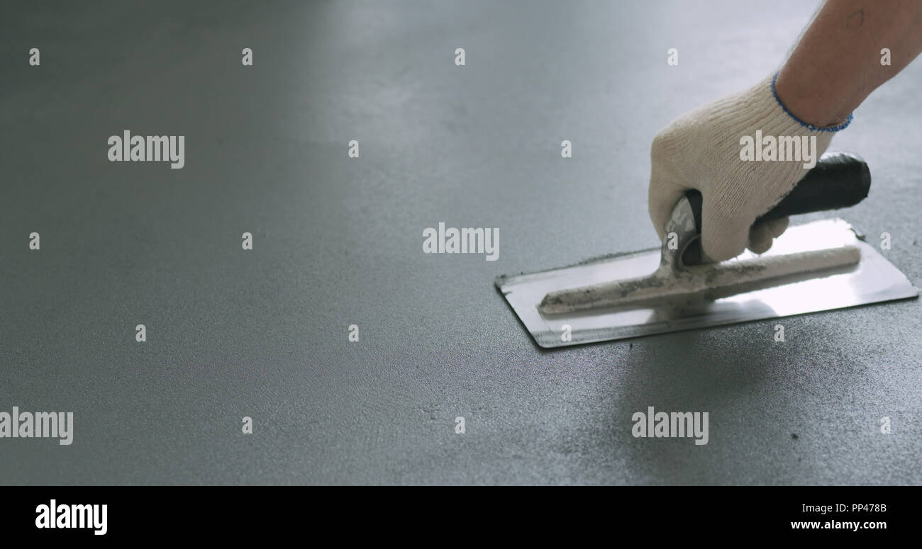 closeup male worker applying micro concrete plaster coating on the ...