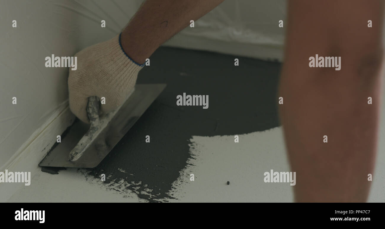 closeup male worker applying micro concrete plaster coating on the ...