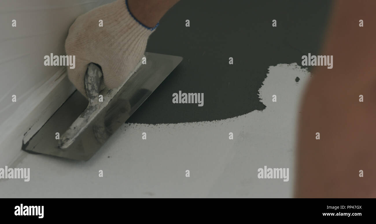 closeup male worker applying micro concrete plaster coating on the ...