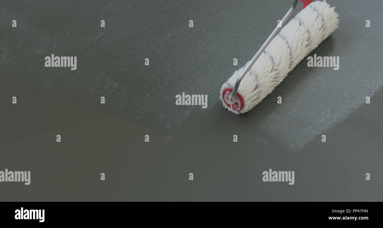 closeup applying protective coating on the concrete floor, wide photo ...