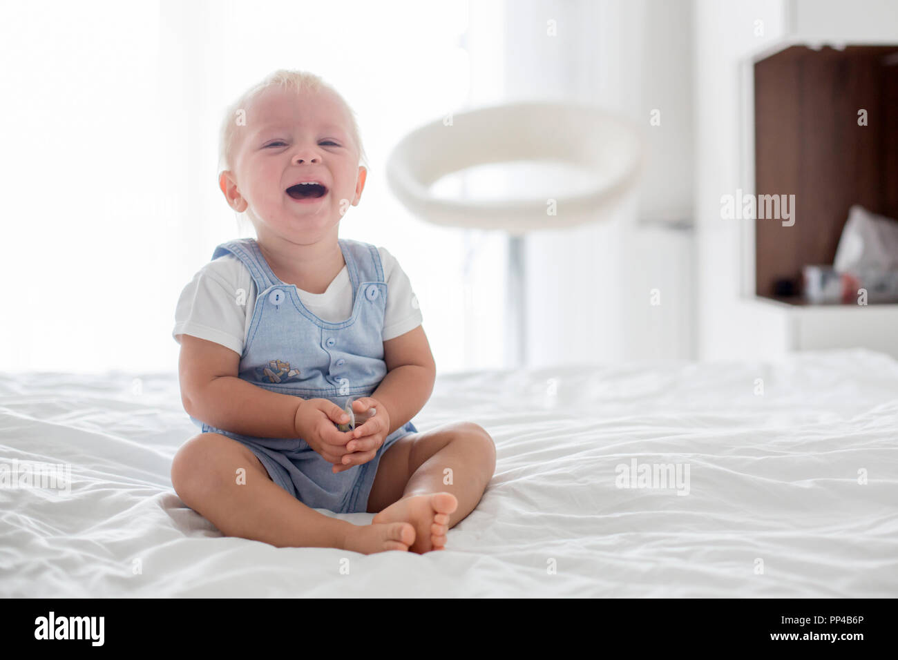 Toddler baby boy, playing with dummy, crying unhappy for the pacifier ...