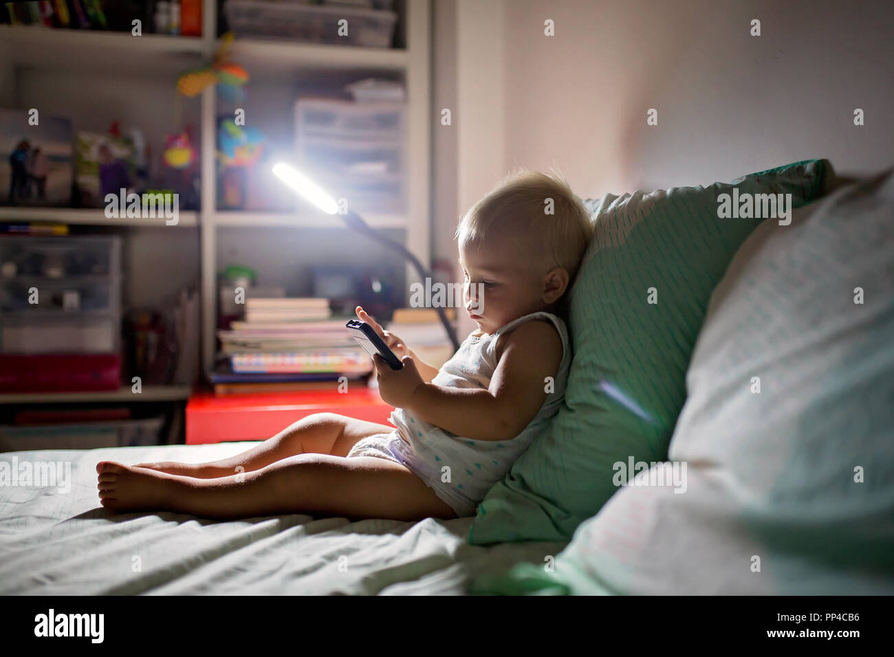 Baby boy, playing in bed at night, dim light Stock Photo - Alamy