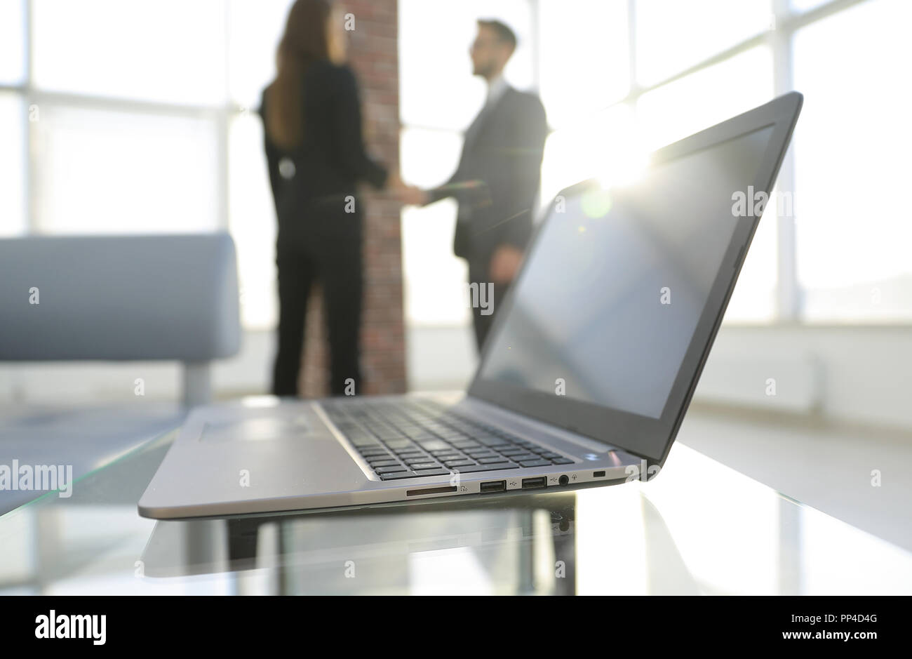 laptop on the desk, background handshake Stock Photo - Alamy